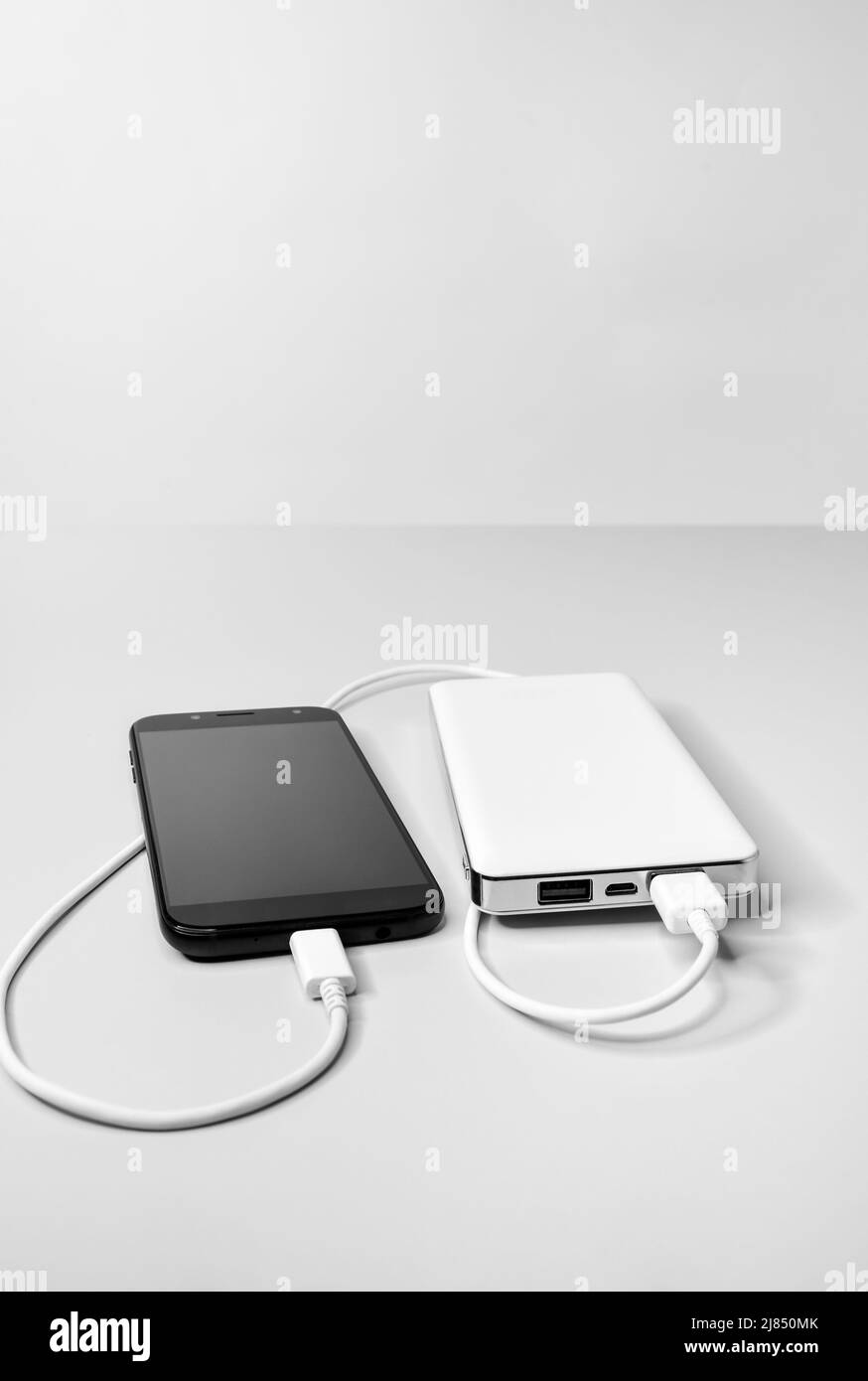 Smartphone is connected with a usb cable and is charged from the power ...