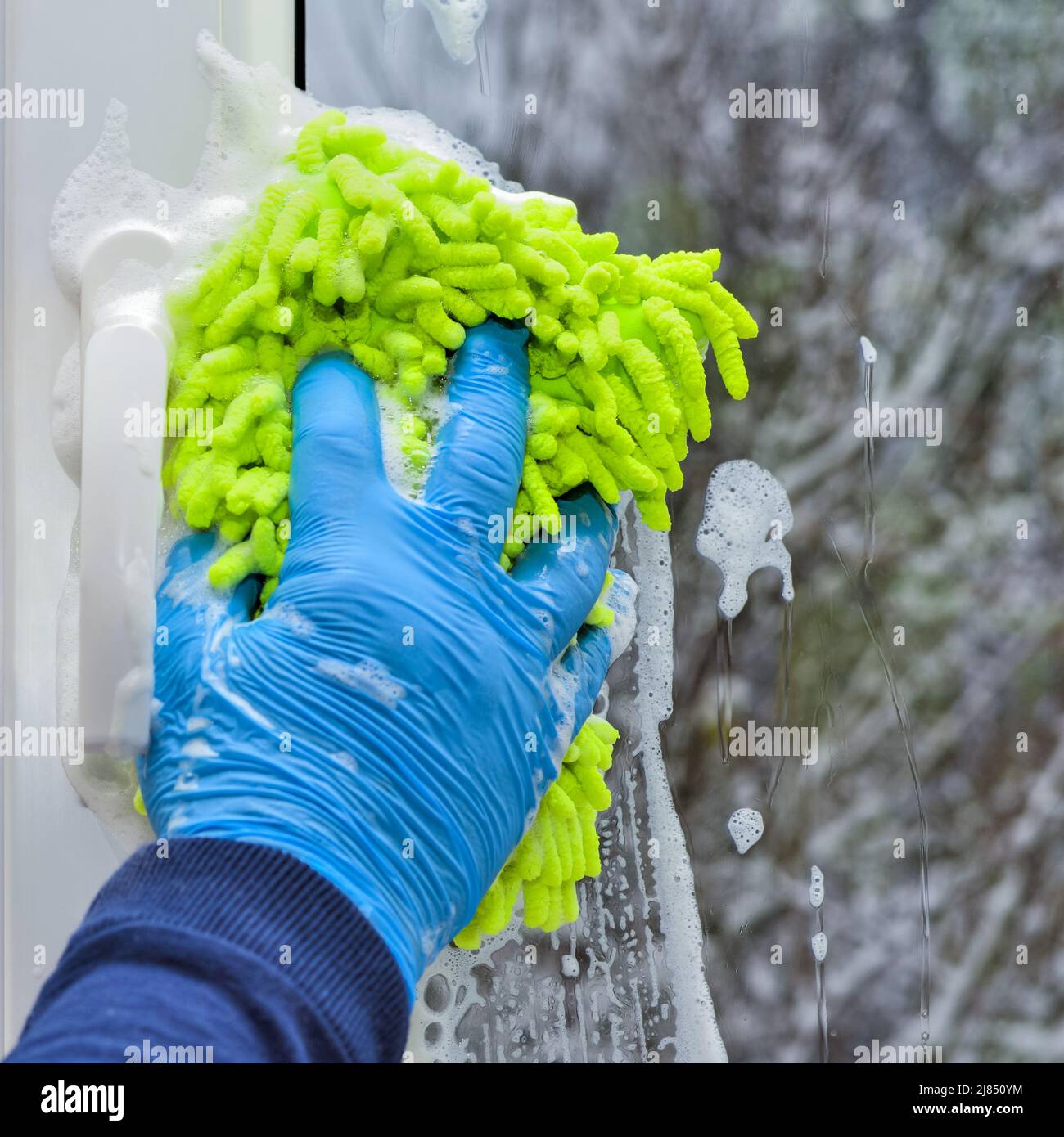 Sponge and foam on glass when cleaning and washing window. House ...