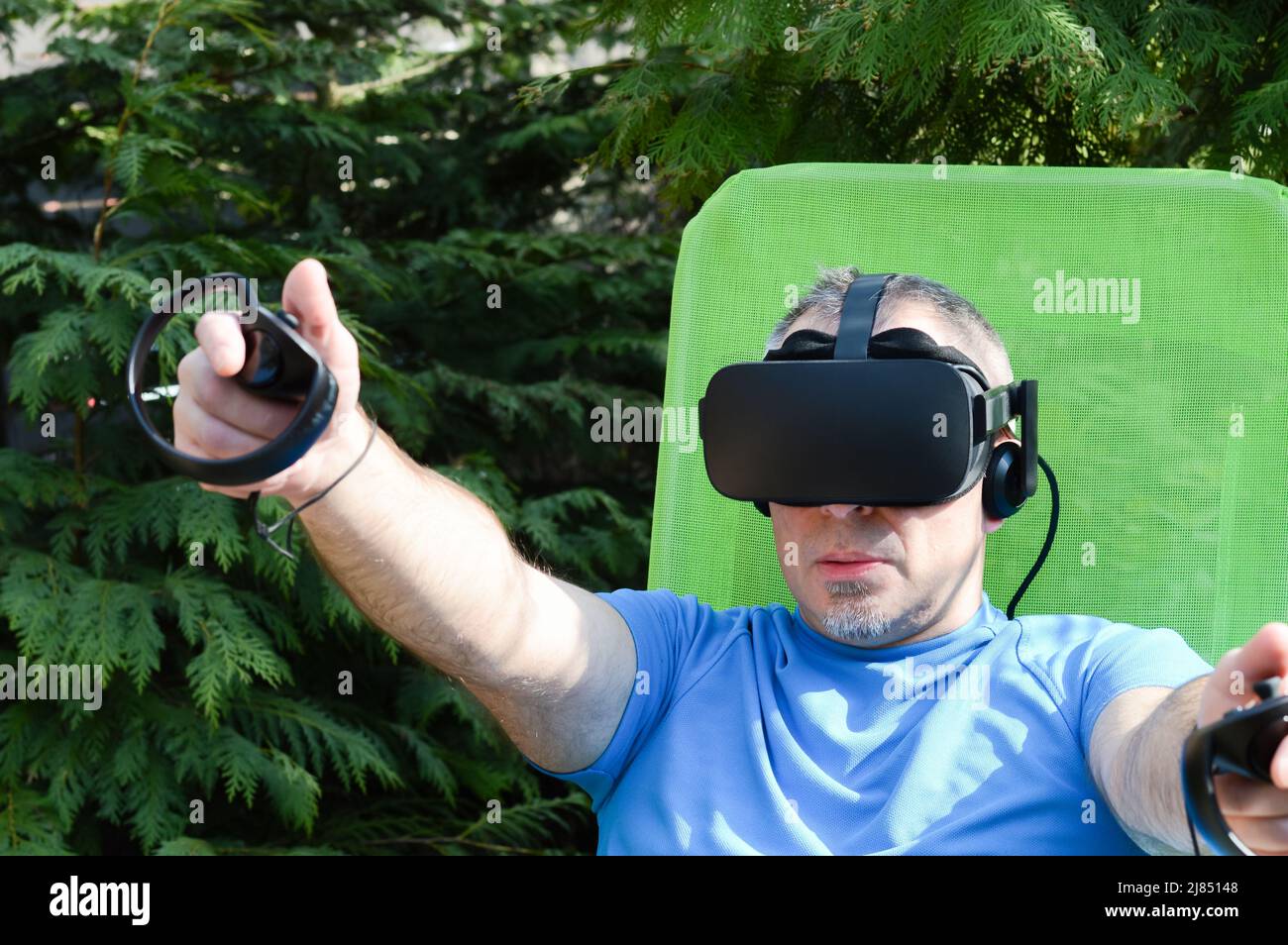 Middle-aged man using virtual reality headset, playing games ...