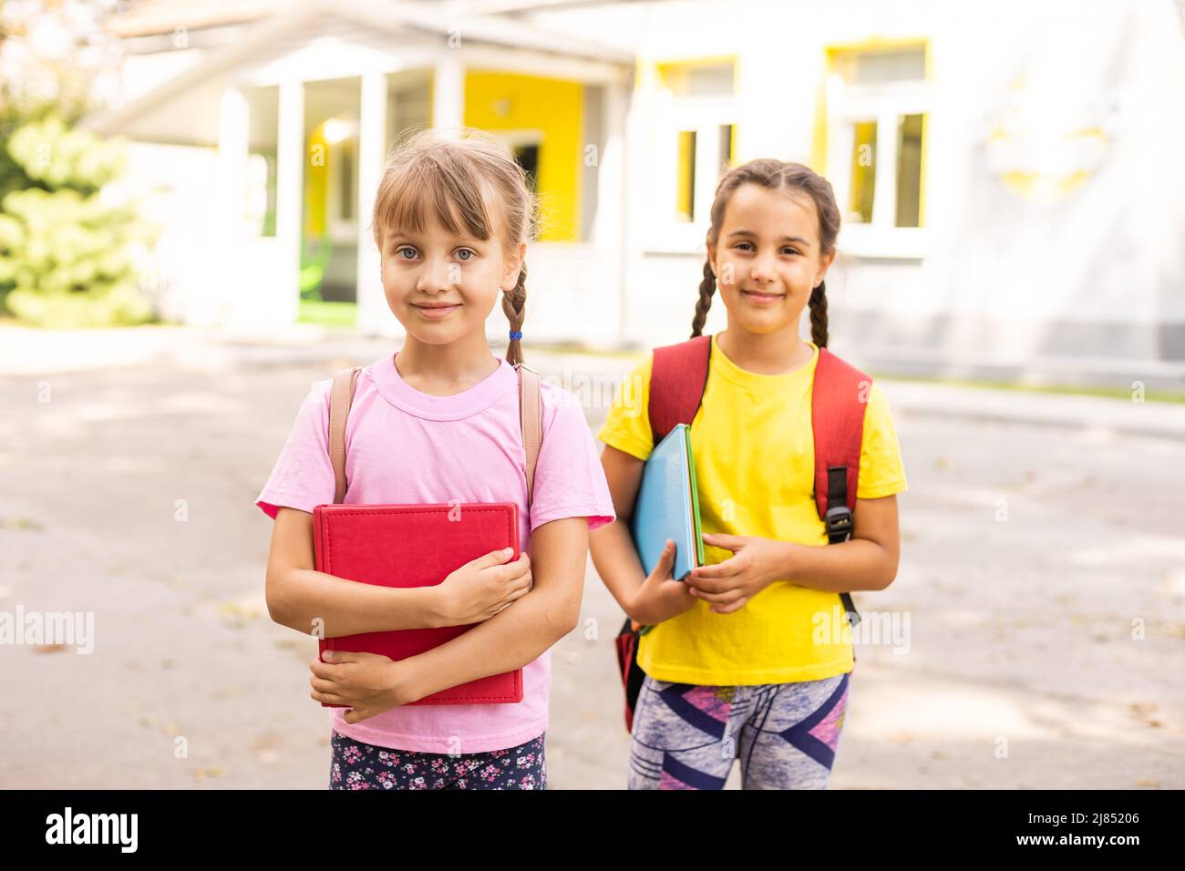 Portrait of two girls with school bags after lesson in school Stock ...