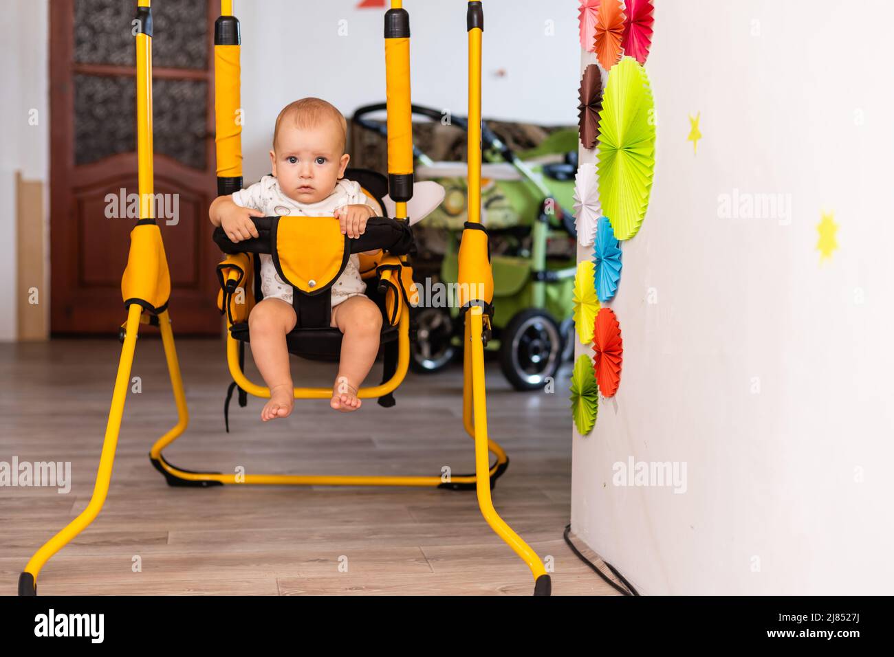 Cute adorable baby sitting in swing, indoors. Closeup of peaceful child ...