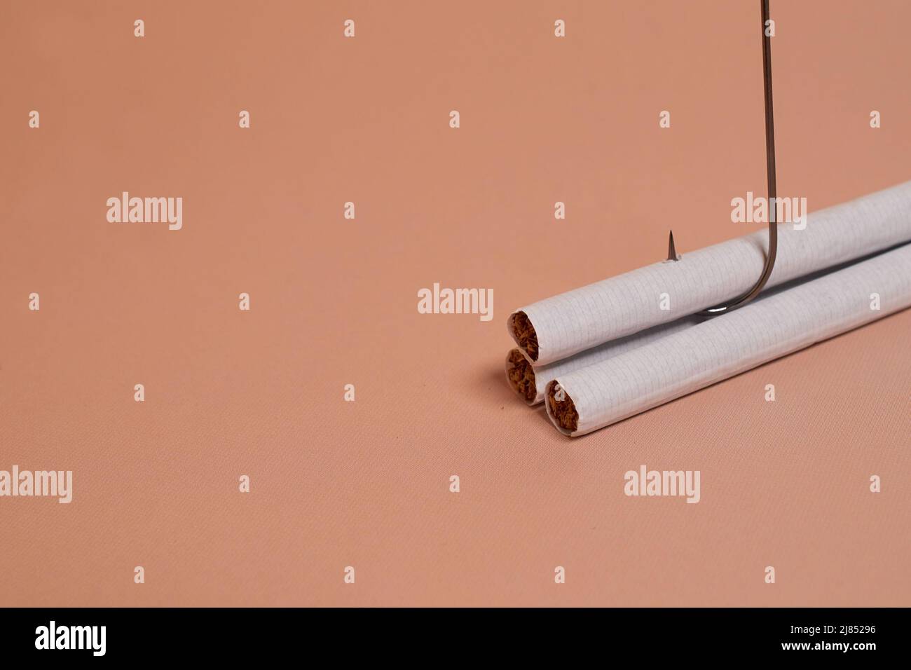 Three cigarettes with a fish hook on a colored background Stock Photo ...