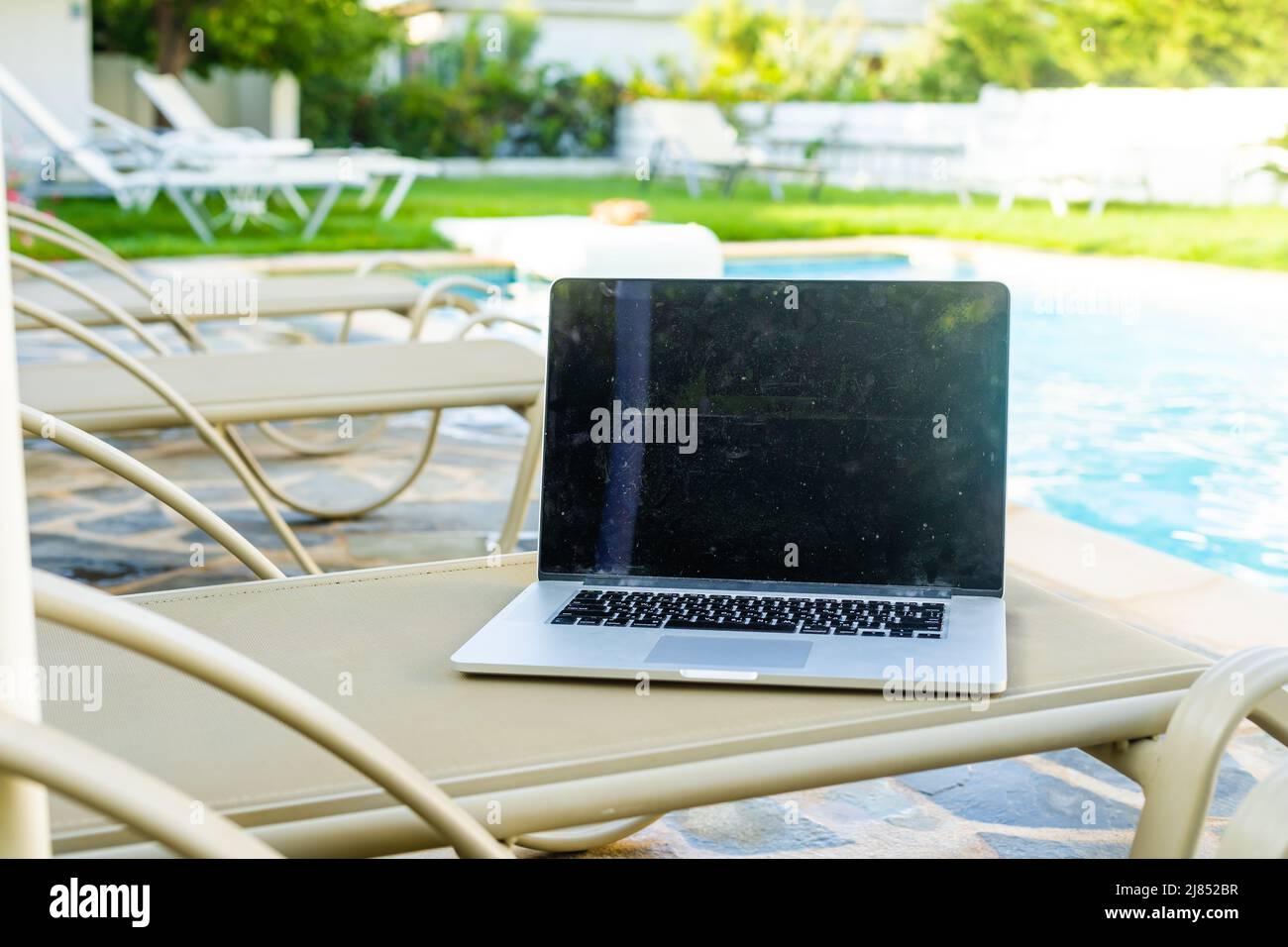 laptop on a sun lounger by the pool Stock Photo - Alamy
