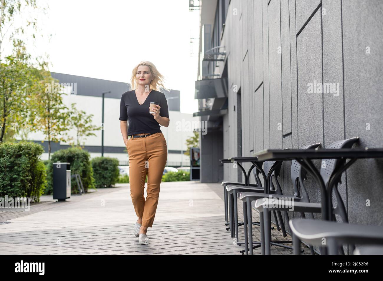 Beautiful Woman Going To Work With Coffee Walking Near Office Building ...