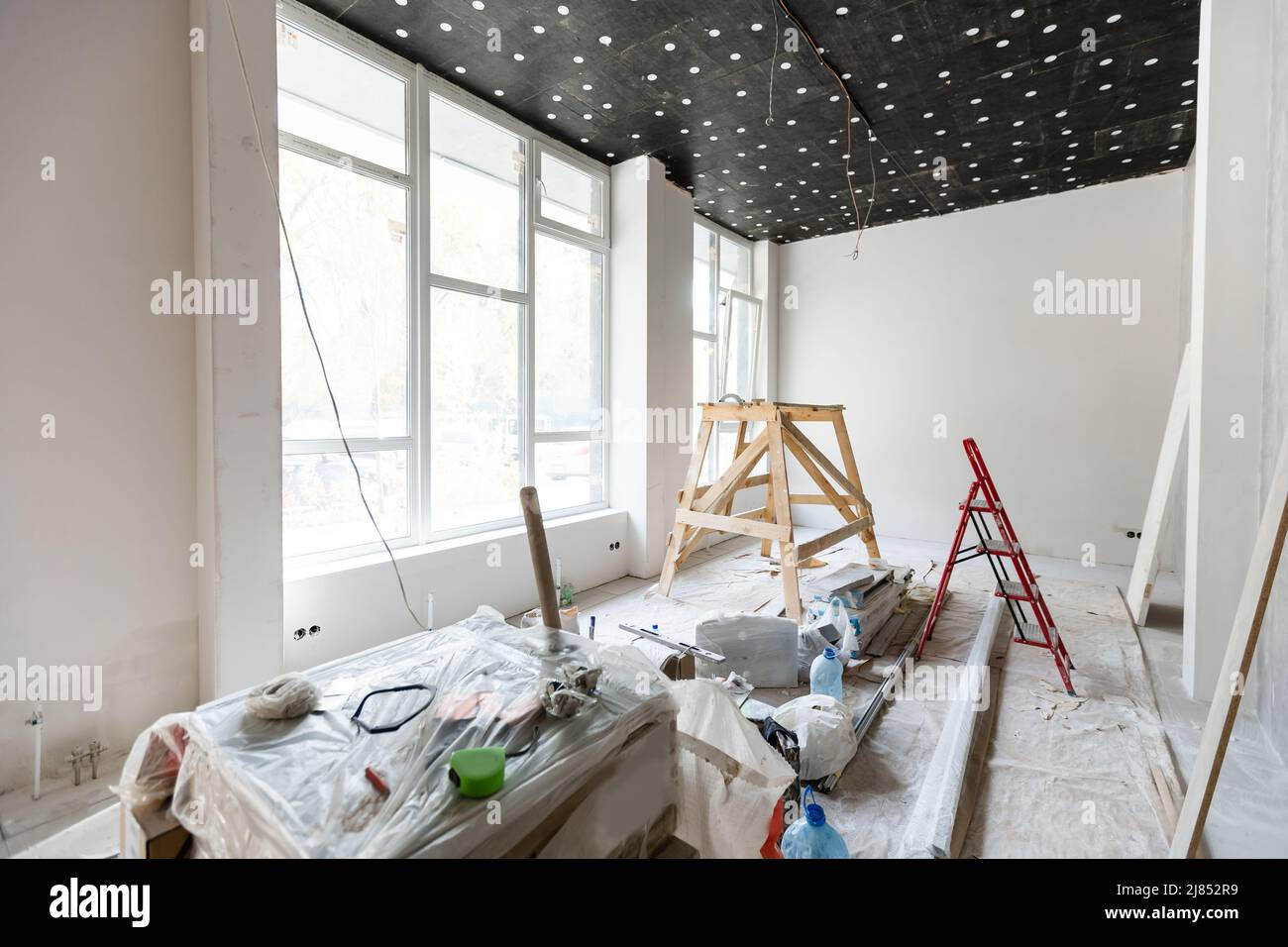 The wall of the building is covered with fresh plaster and surrounded ...