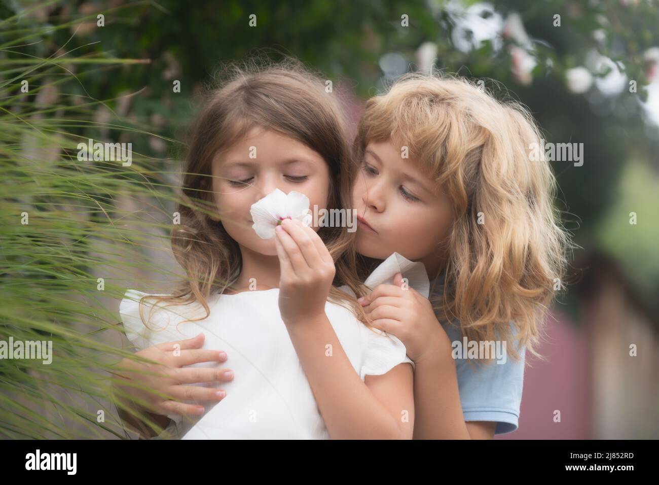Child boy and girl hugging each other with love in the spring garden ...
