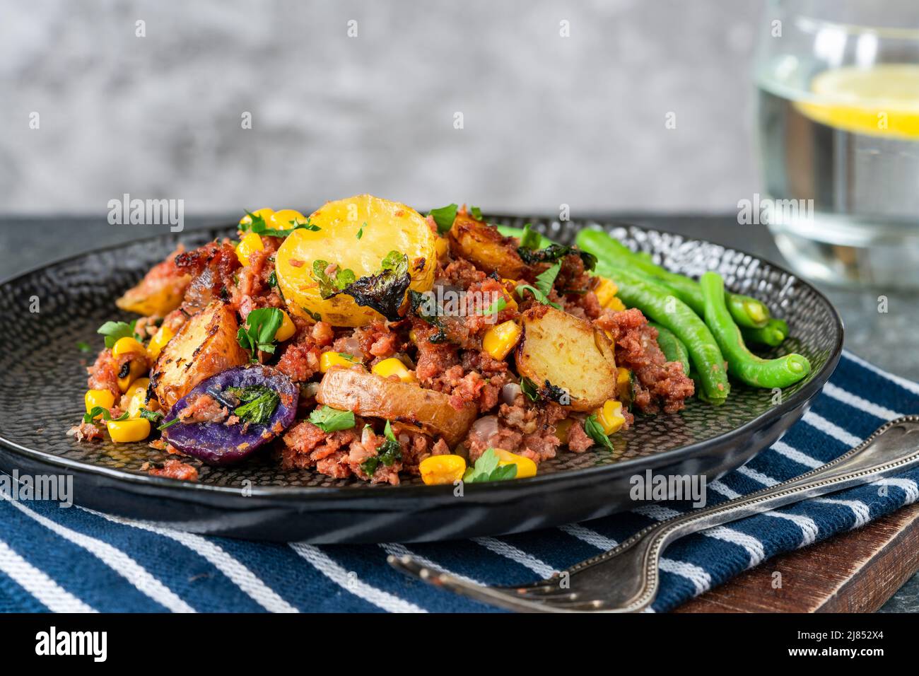 Corned beef, sweetcorn and potato hash with green beans Stock Photo - Alamy