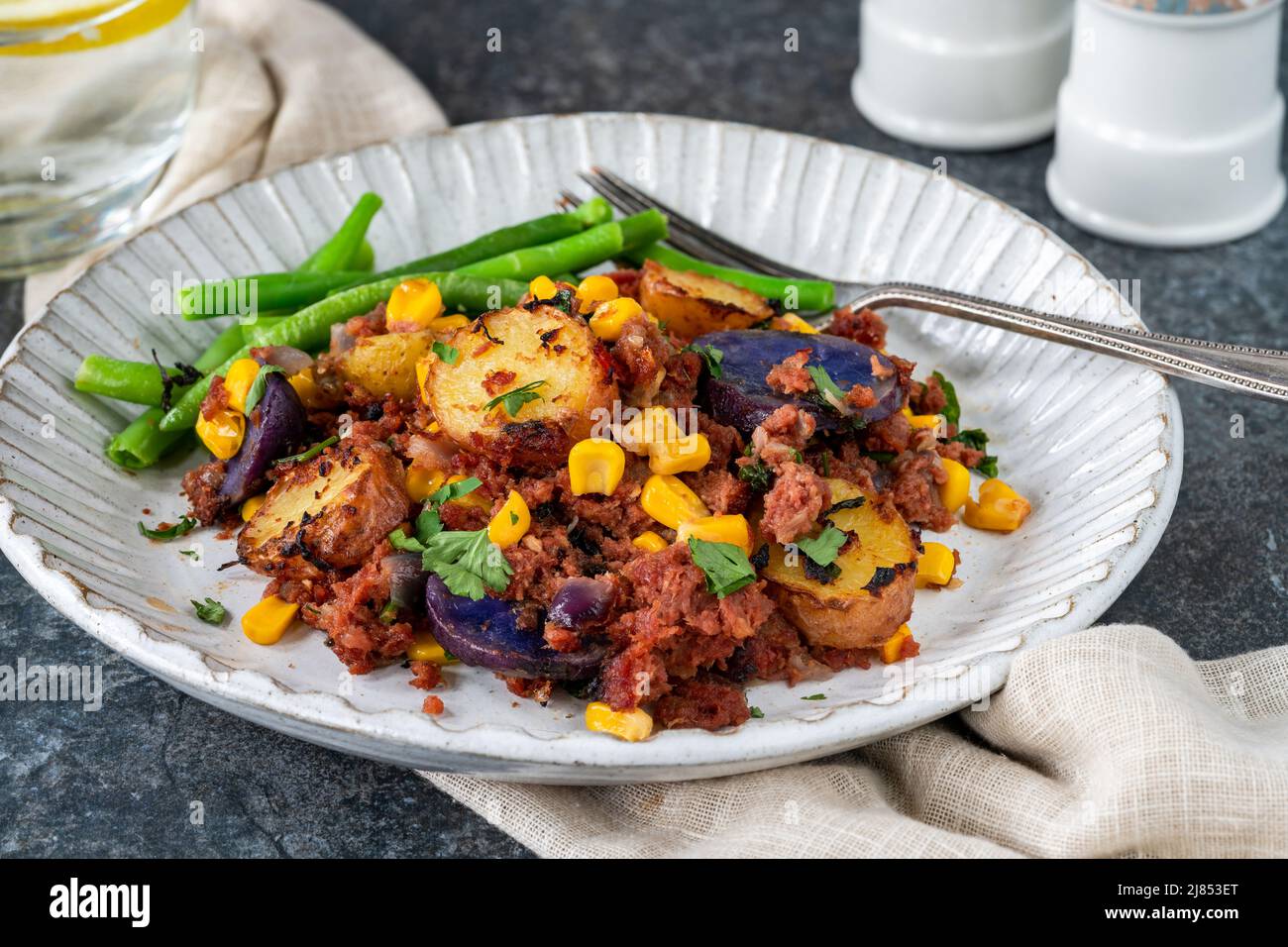 Corned beef, sweetcorn and potato hash with green beans Stock Photo - Alamy