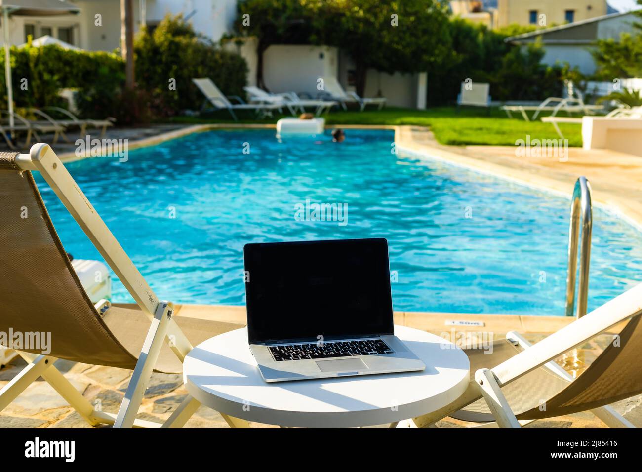 laptop computer on table pool background Stock Photo - Alamy