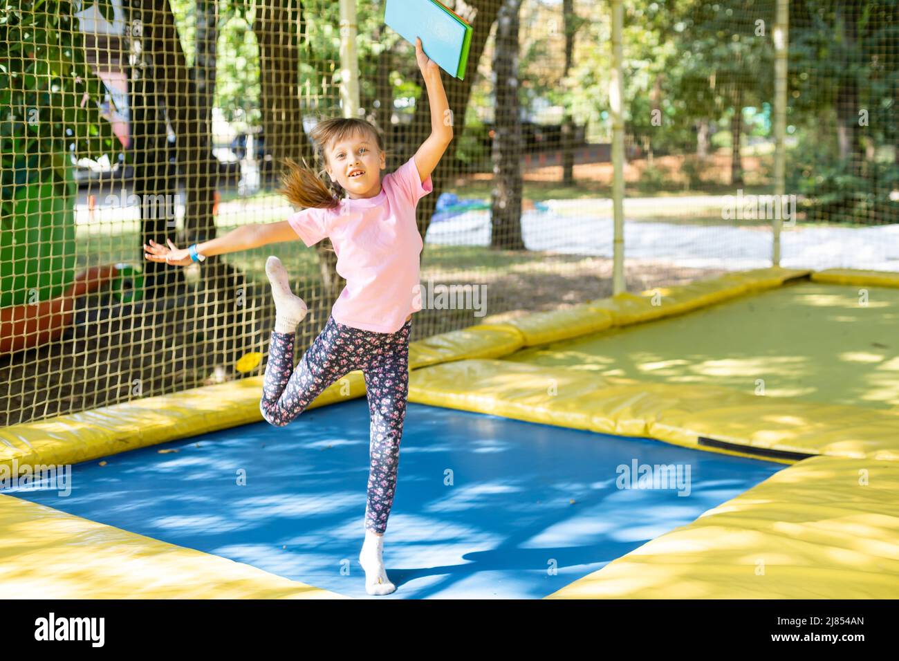 Little child enjoys jumping on trampoline - outside in backyard Stock ...