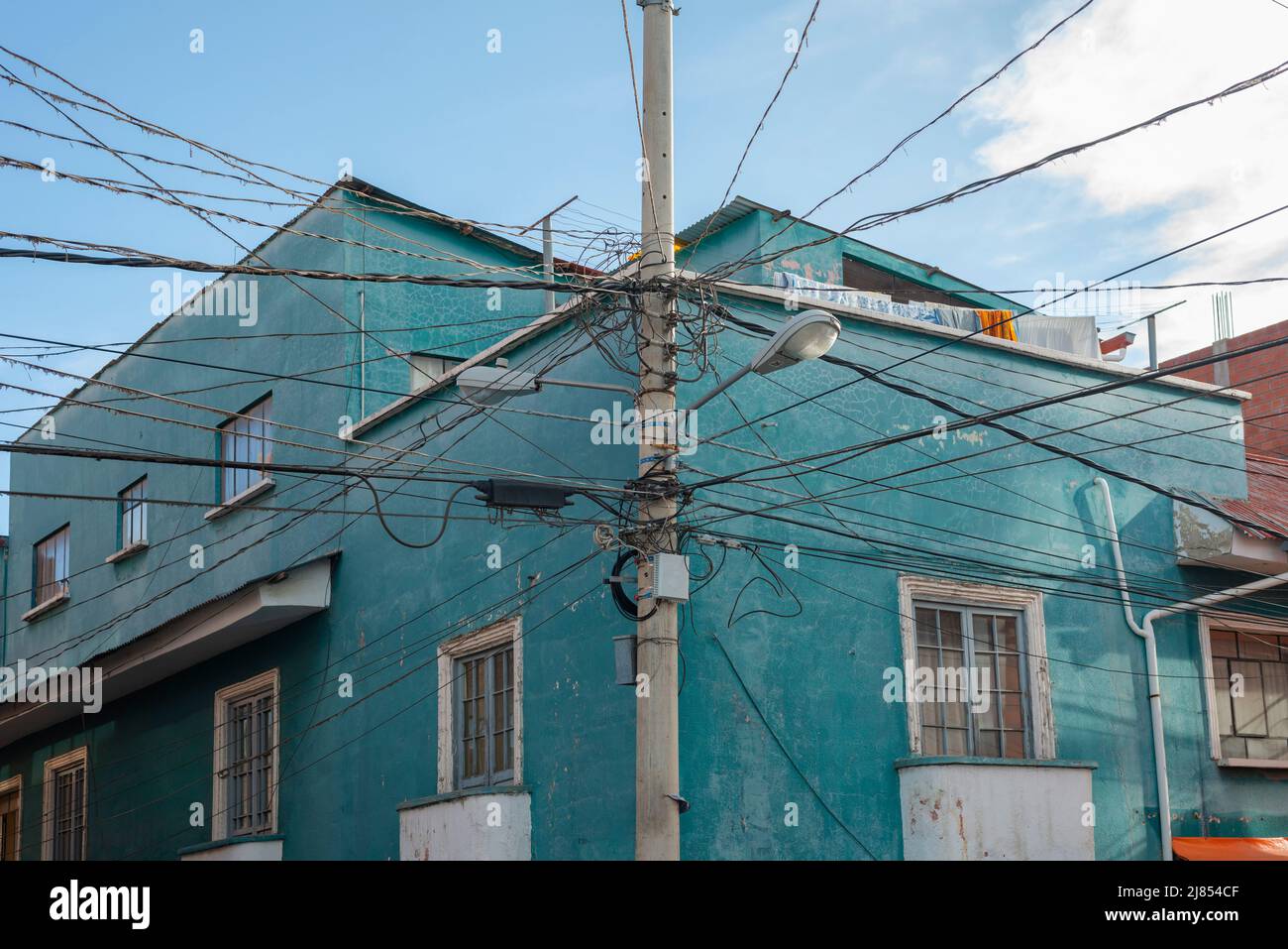 town street fragment with focus on many hanged wires and cables ...