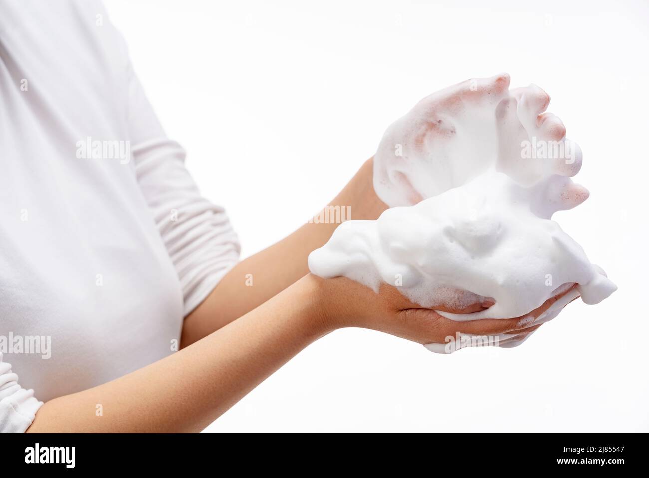 Female holding soap bubbles on white background. Hands with white ...