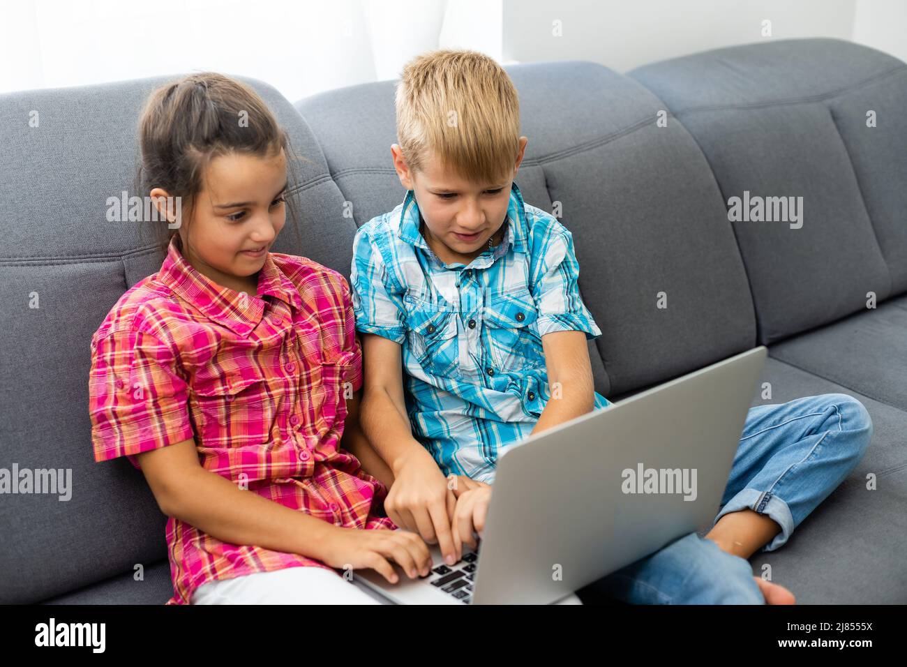 Kids playing with laptop computer at home Stock Photo - Alamy