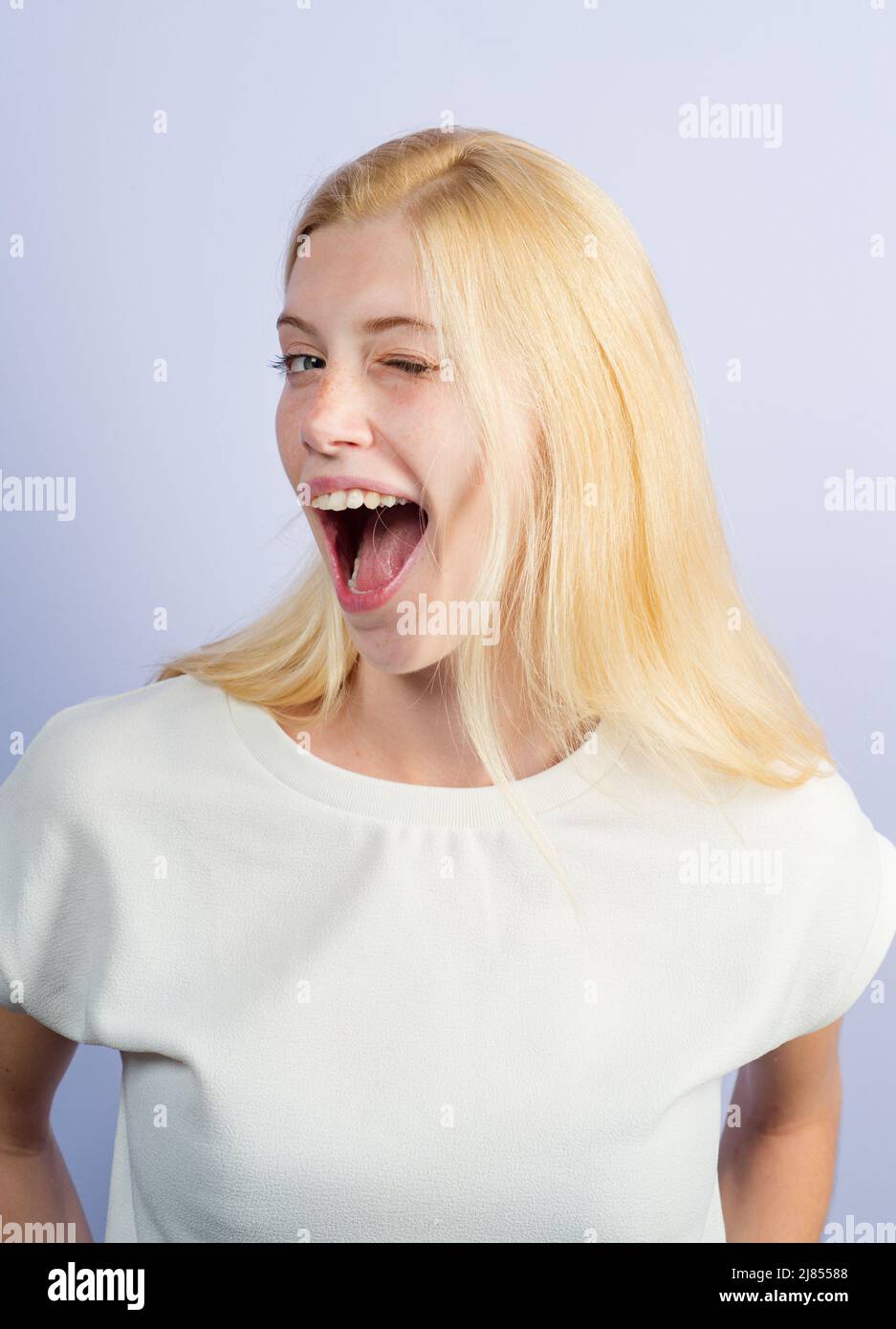 Woman isolated on white background winking. Funny young girl winks ...