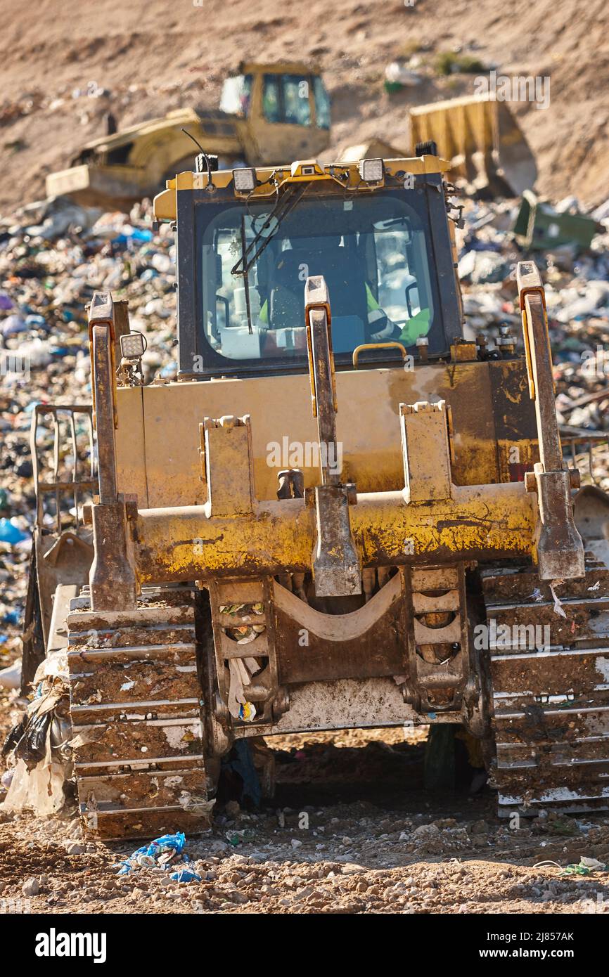 Heavy machinery shredding garbage in an open air landfill. Waste Stock ...