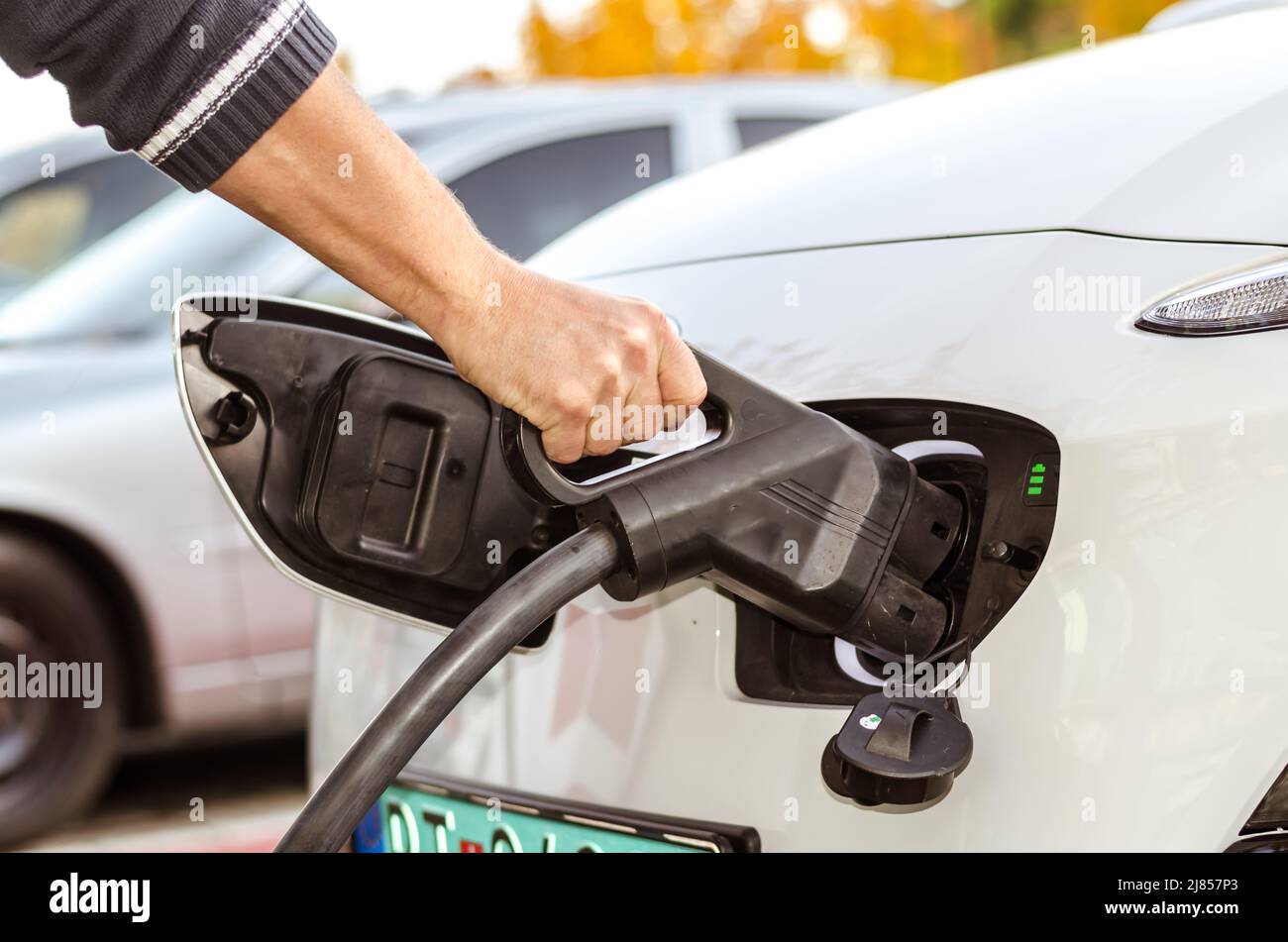 human hand with charger charging eco green alternative electric vehicle ...