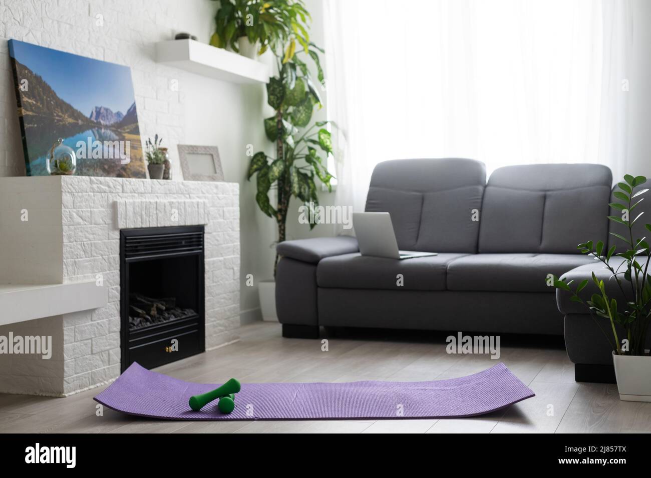 Training at home concept, grey sofa and mat style Stock Photo - Alamy