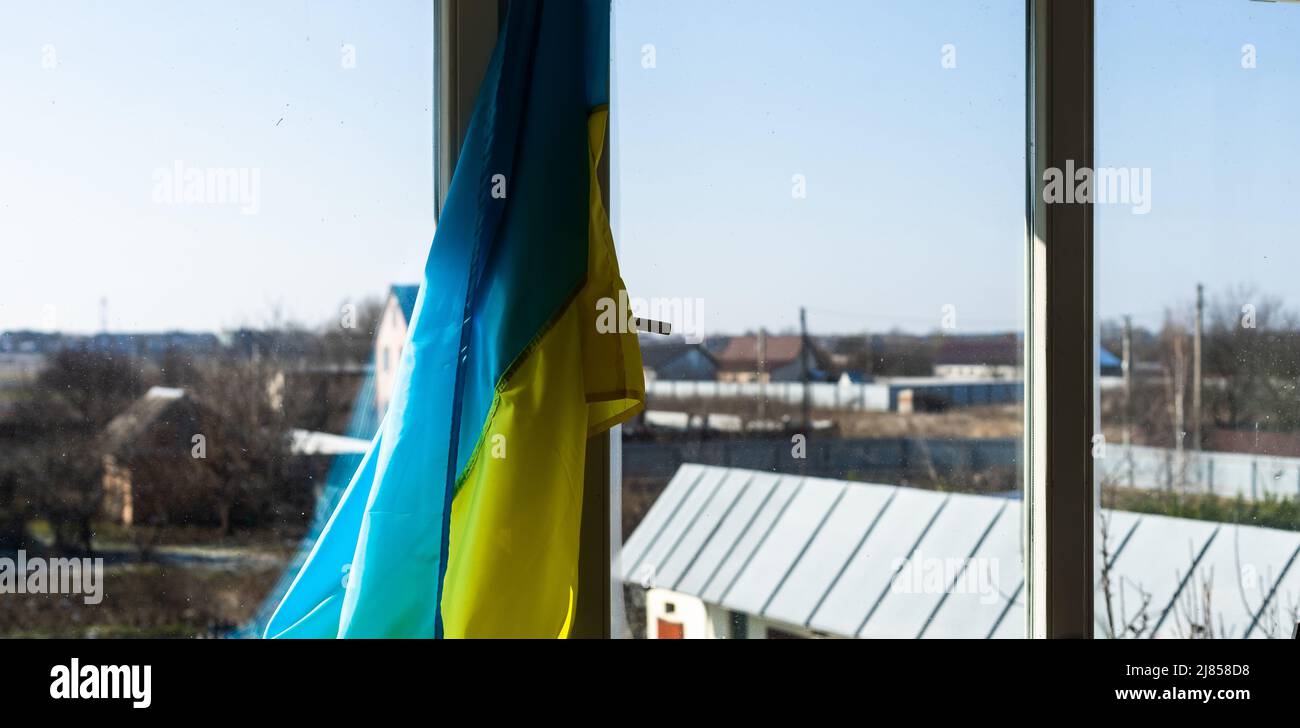 Flag of Ukraine on the window sealed with tape. No war. War in Ukraine ...
