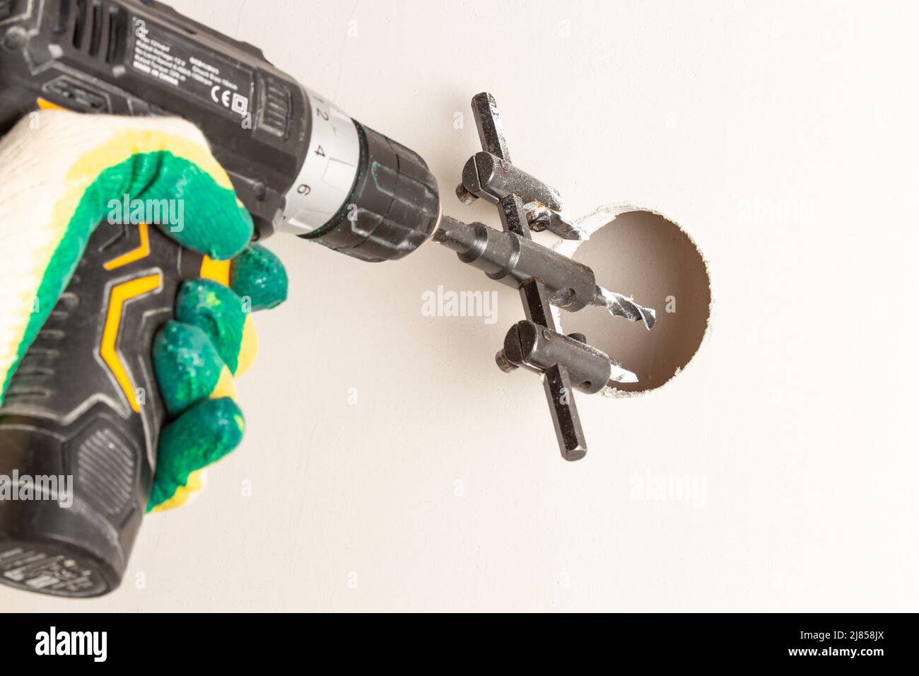The process of drilling and preparing holes in drywall, construction ...