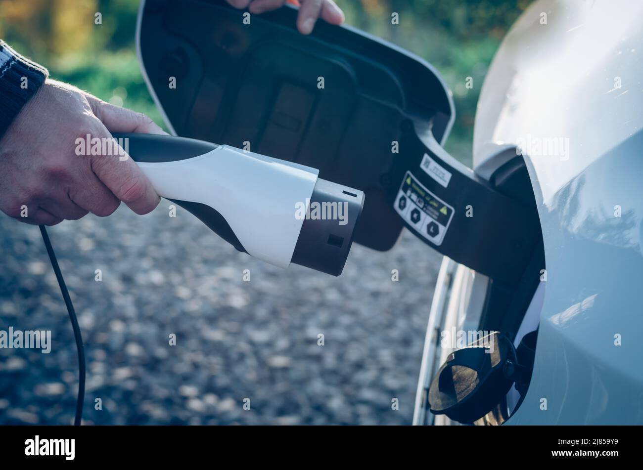 human hand with charger charging eco green alternative electric vehicle ...