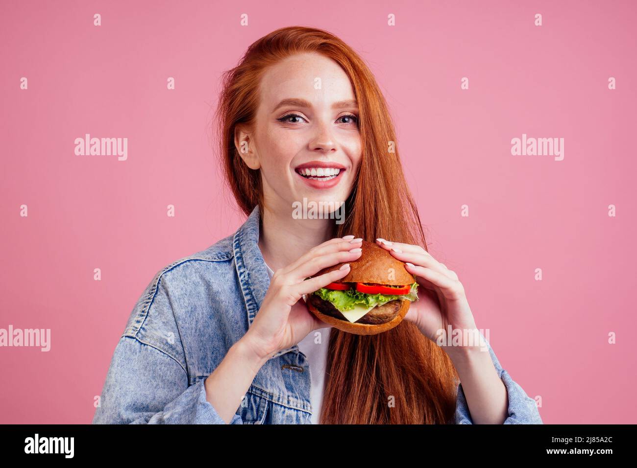 redhaired ginger woman with freckles enjoying big huge burger cutlet ...