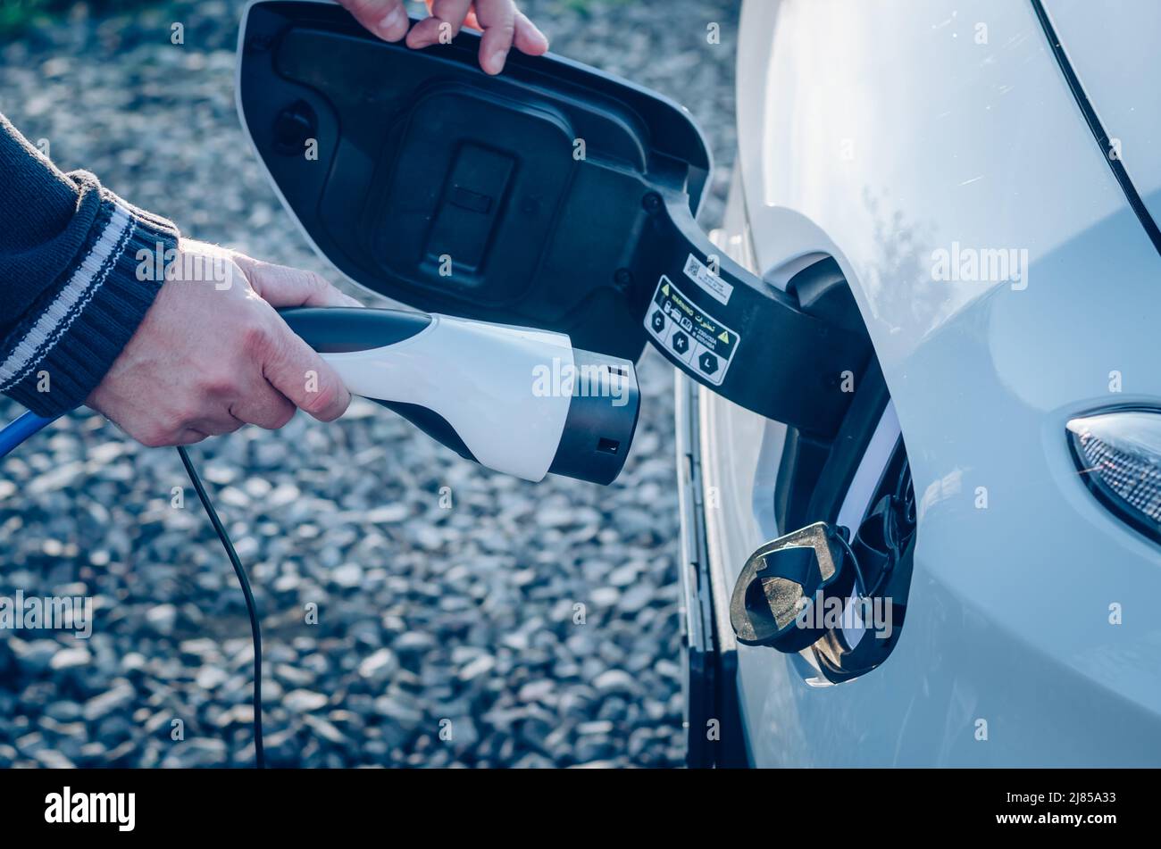 human hand with charger charging eco green alternative electric vehicle ...