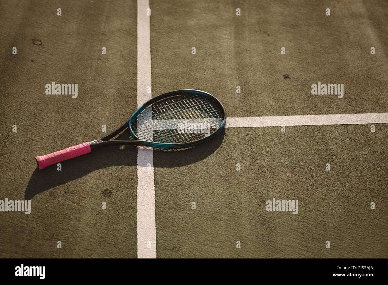 High angle view of tennis racket on white lines at tennis court during ...