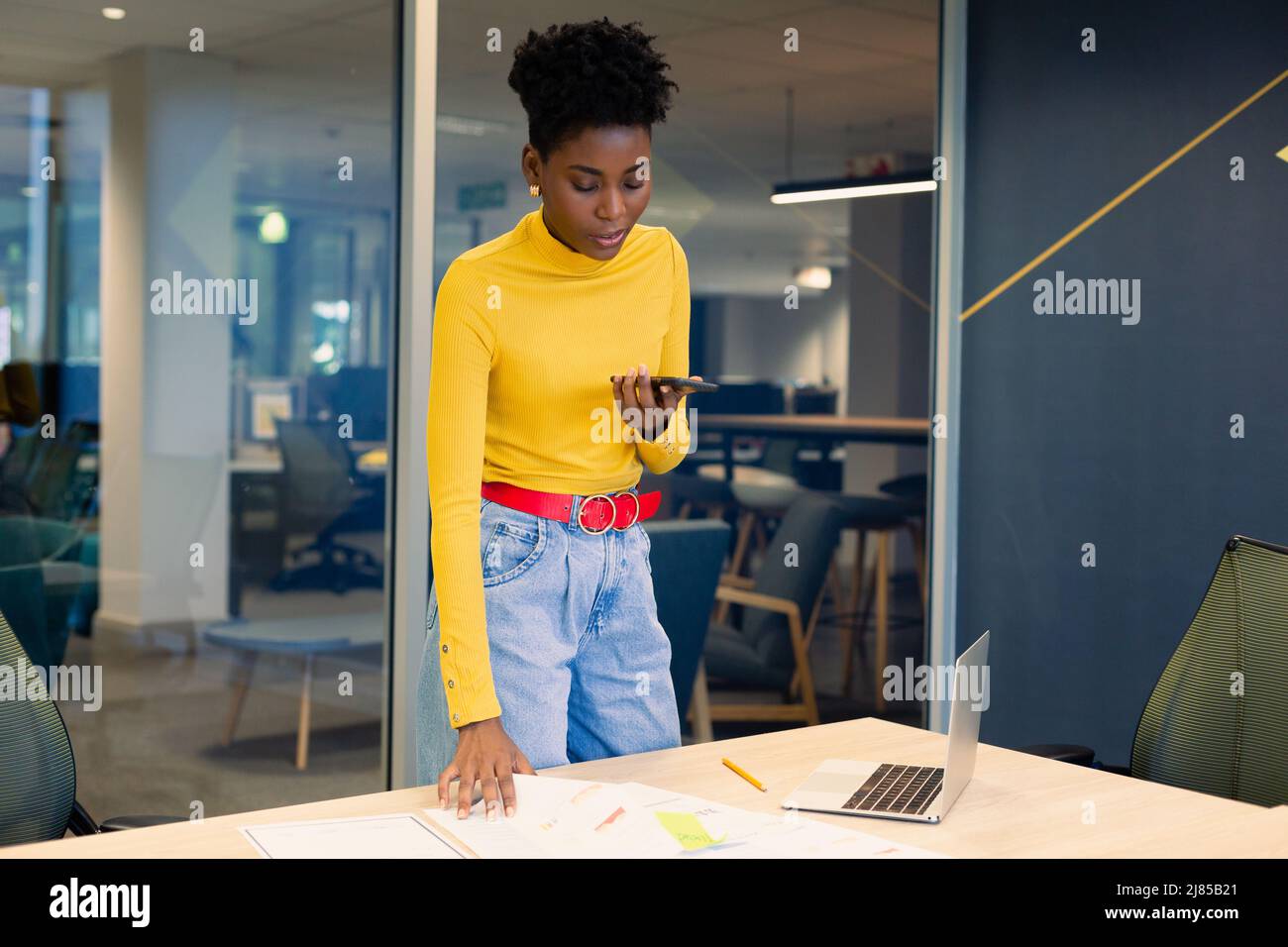 Young african american businesswoman holding smartphone analyzing ...