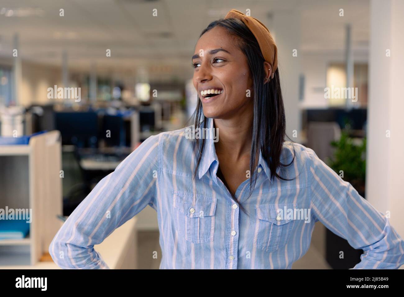 Happy young female african american advisor looking away at modern ... Happy young female african american advisor looking away at modern ...