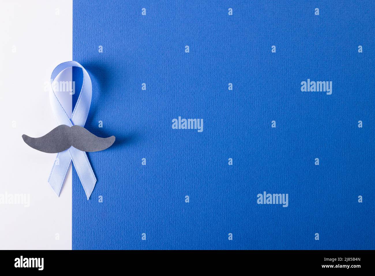 Overhead view of blue prostate cancer awareness ribbon with paper ...