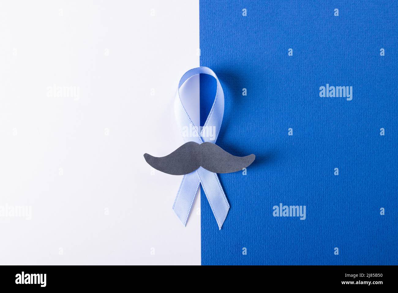 Overhead view of blue prostate cancer awareness ribbon with paper ...