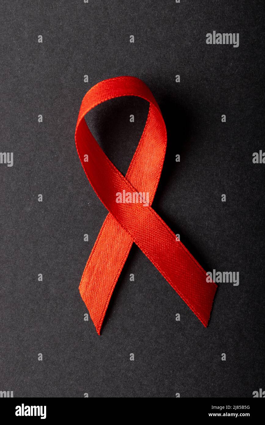 Overhead close-up of red aids awareness ribbon isolated against black ...