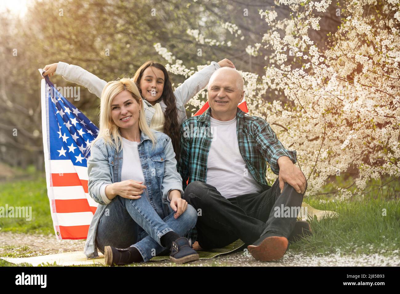 Patriotic family holding the usa flag outdoors. Happy aged caucasian ...