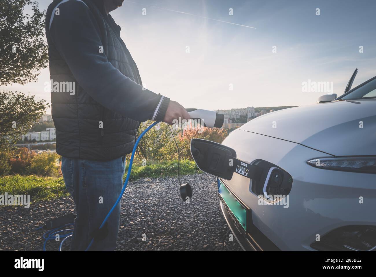 human hand with charger charging eco green alternative electric vehicle ...