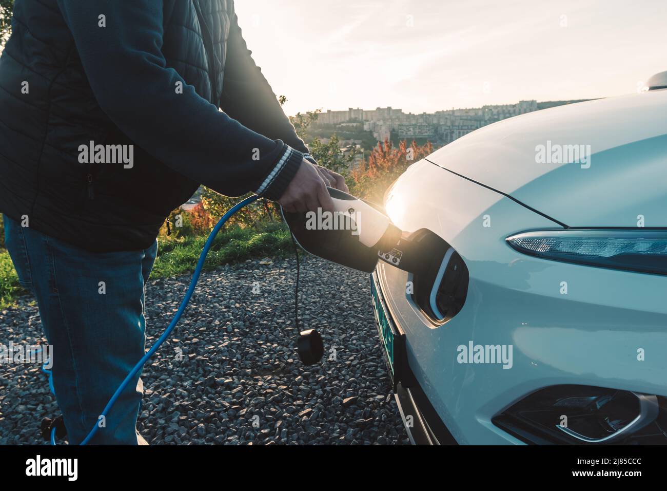 human hand with charger charging eco green alternative electric vehicle ...