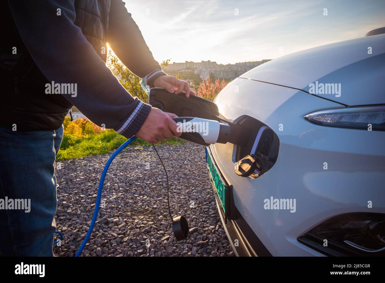 human hand with charger charging eco green alternative electric vehicle ...