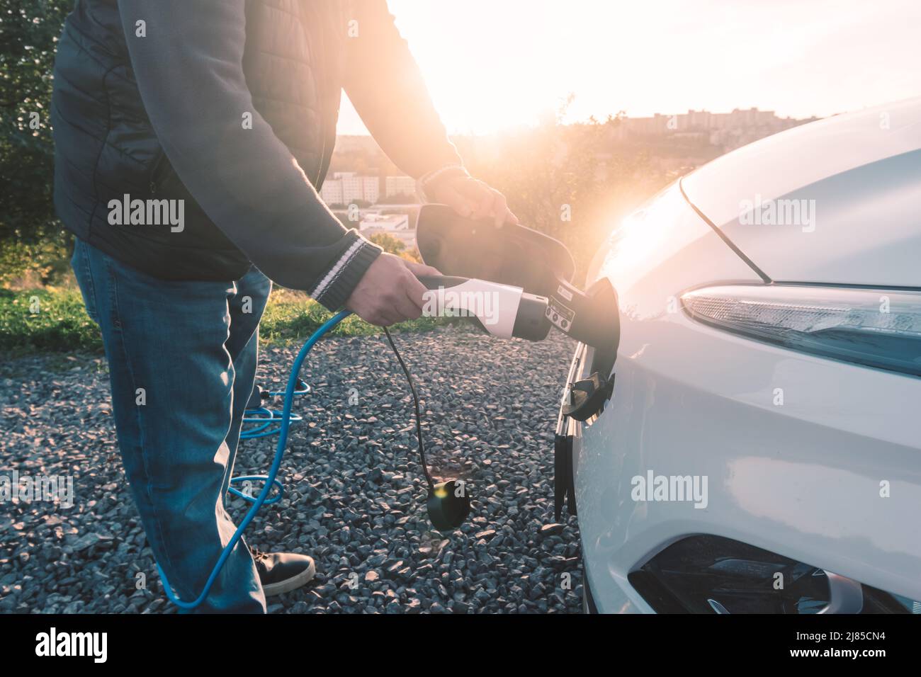 human hand with charger charging eco green alternative electric vehicle ...
