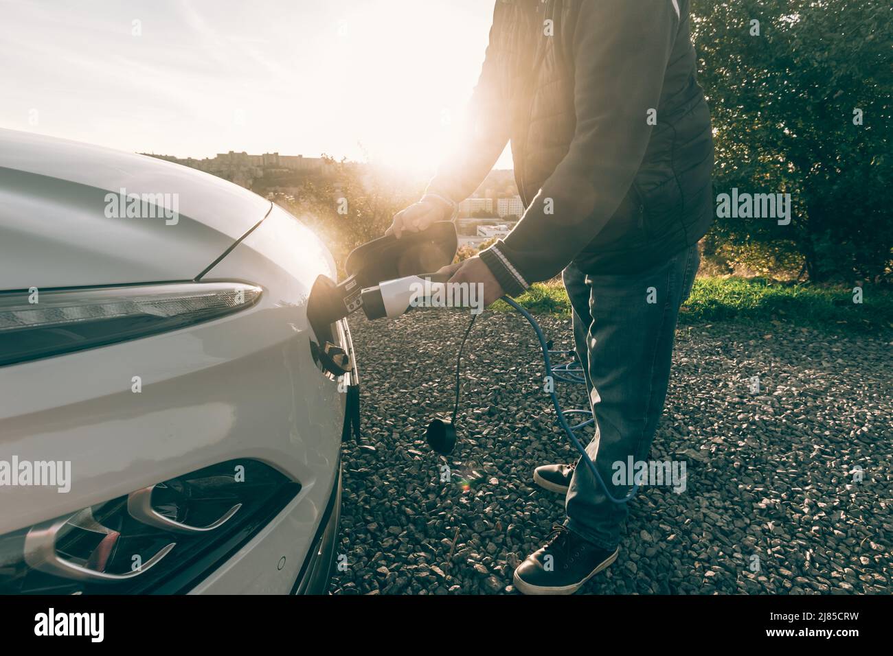 human hand with charger charging eco green alternative electric vehicle ...