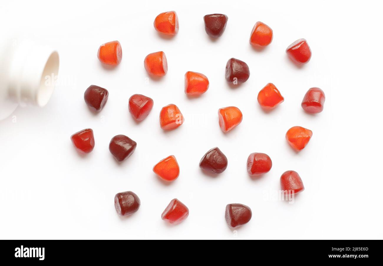 Group of red, orange and purple multivitamin gummies with the bottle ...