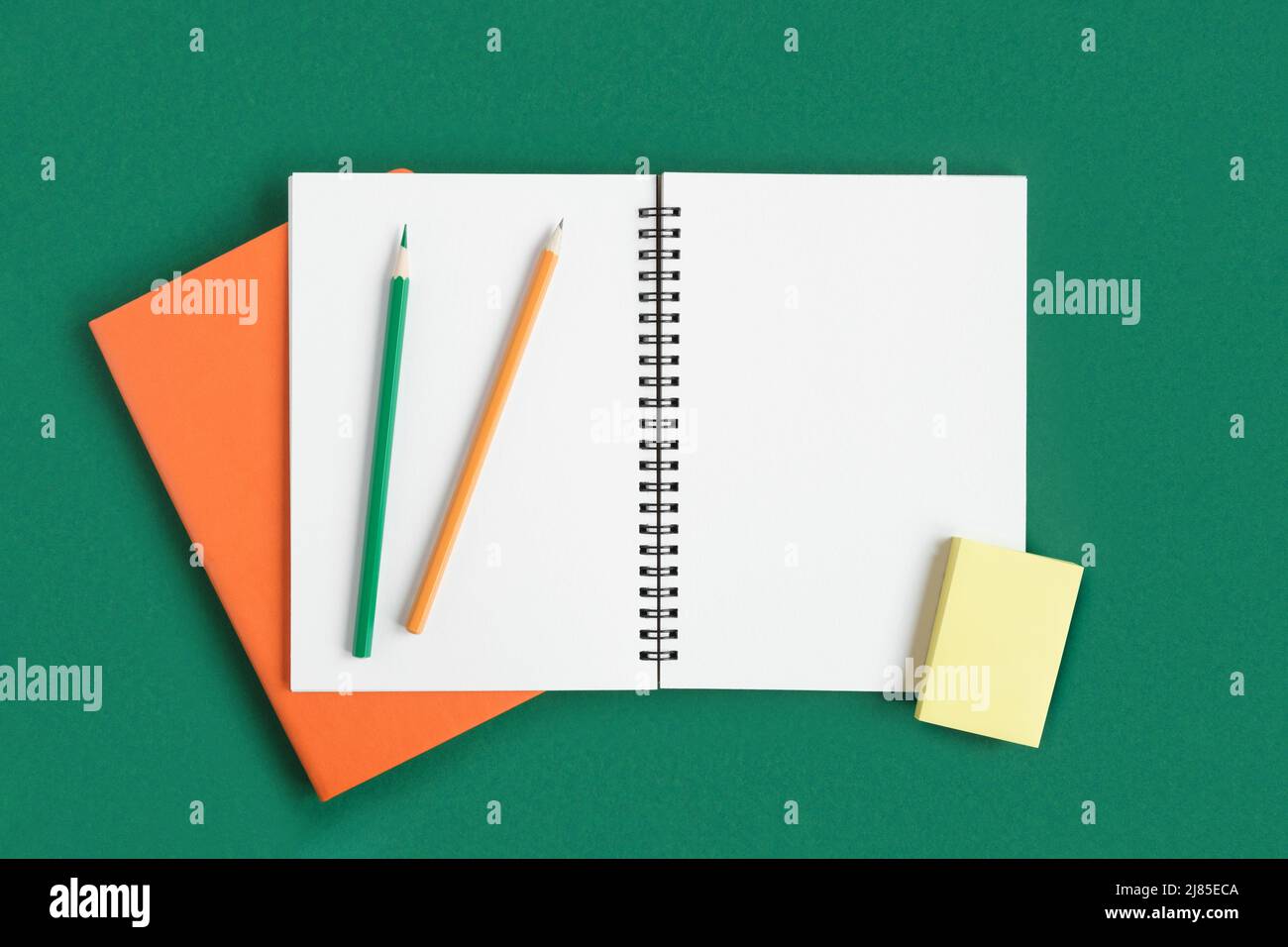 Notebook with pencil. Open notebook on dark green color background ...