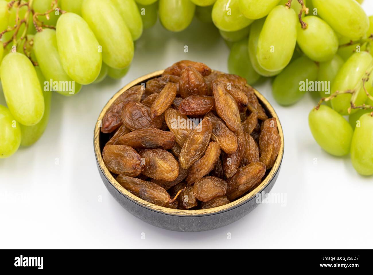Dried raisins on a white background. Raw grapes and raisins. Healthy ...