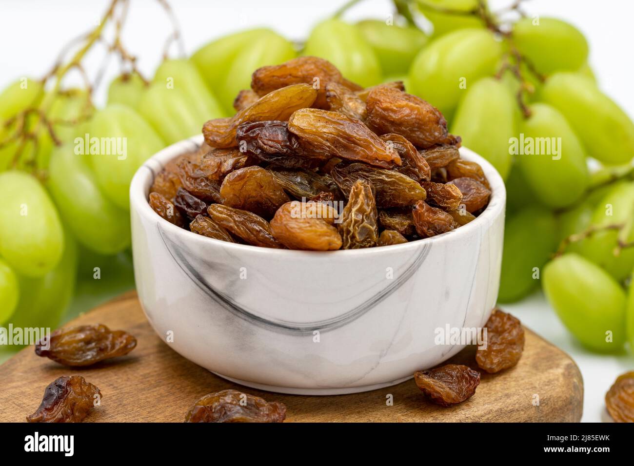 Dried raisins on a white background. Raw grapes and raisins. Healthy ...