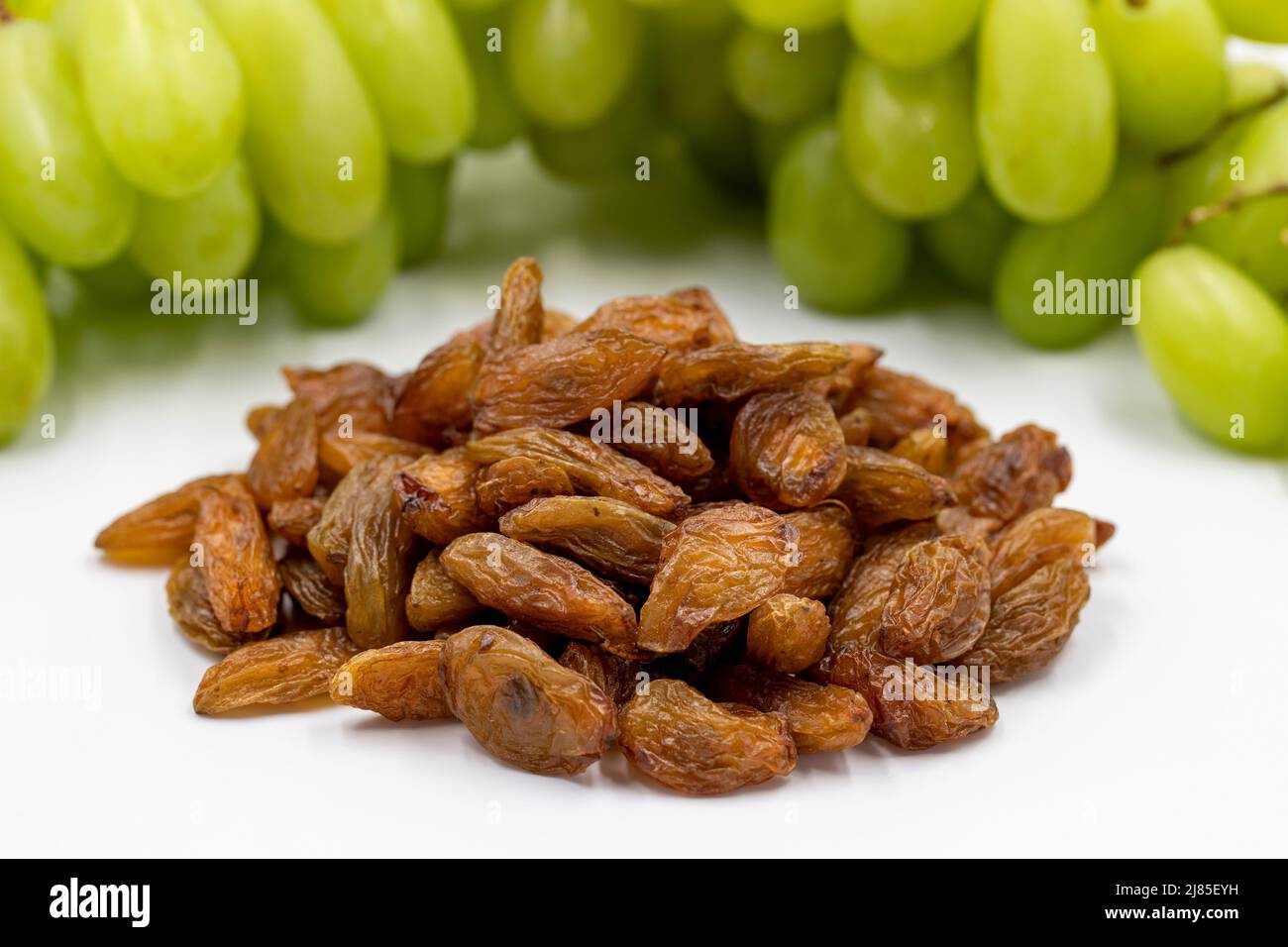 Dried raisins on a white background. Raw grapes and raisins. Healthy ...