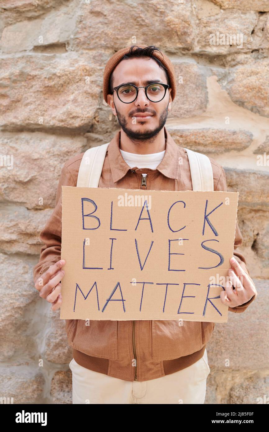 Portrait of sad Arabian bearded man in eyeglasses holding protest ...