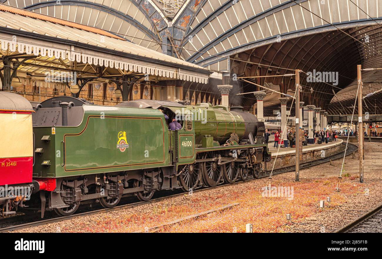Old steam train arrives at a historic railway station platform ...