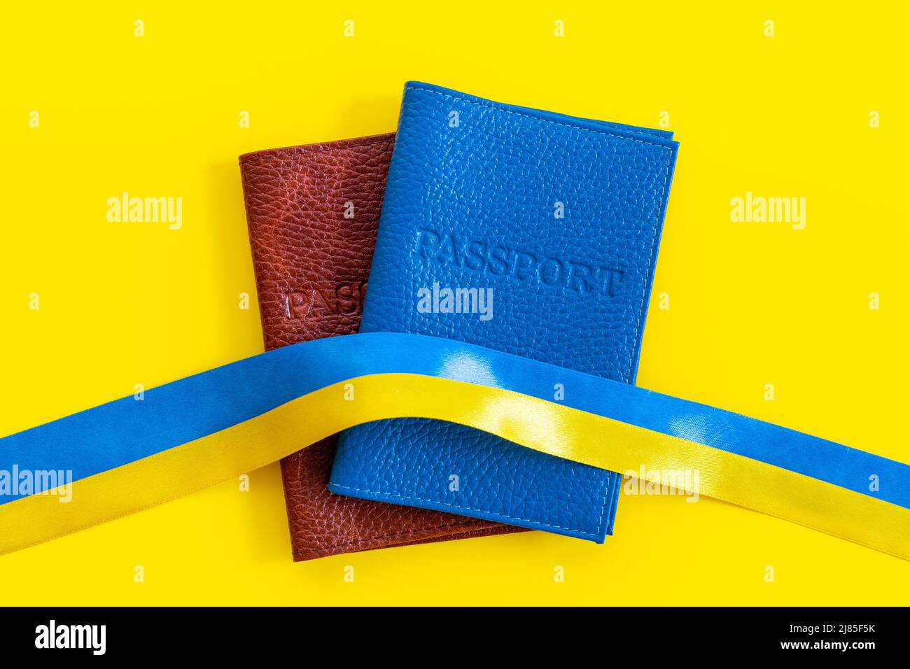 Ukrainian immigration concept - yellow and blue ribbon on passport ...