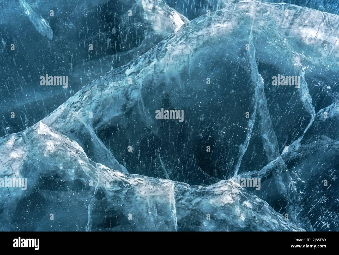 Transparent blue ice of frozen Baikal lake with waves pattern ...