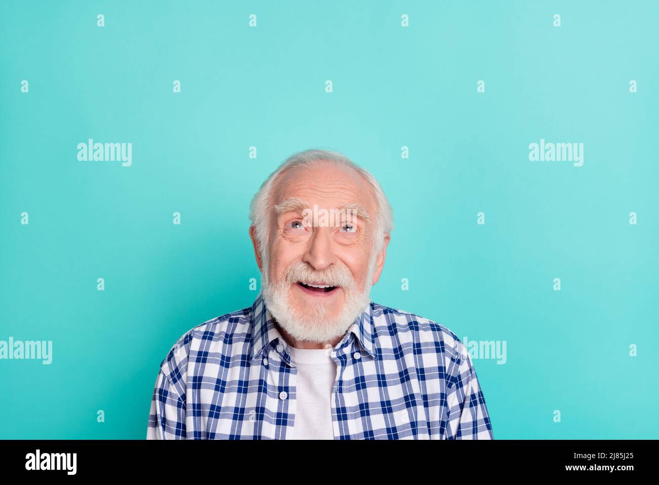 Portrait of cute dreamy granddad looking up blank space see promotional ...