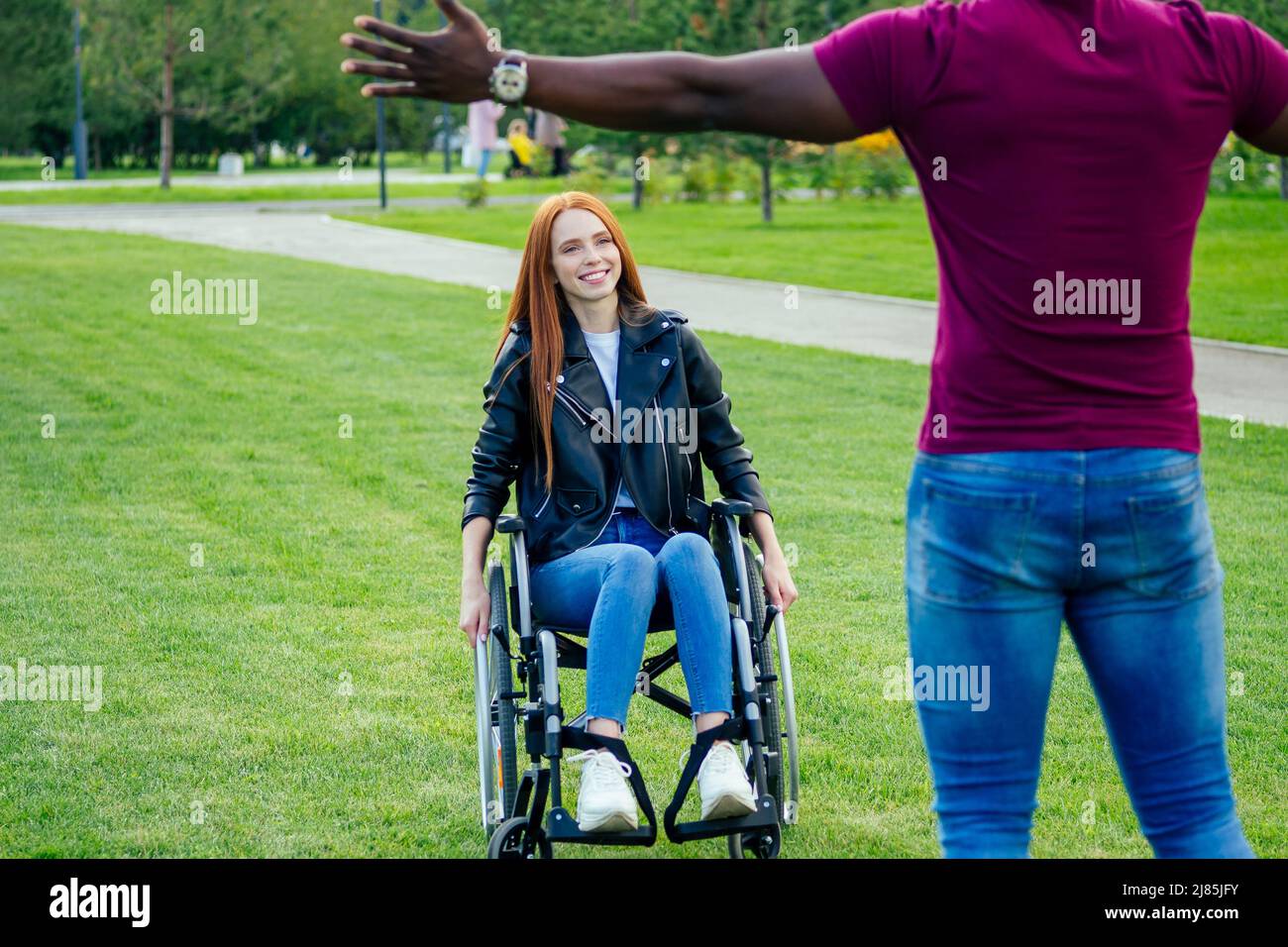 afro american man sitting on wheelchair ,his redhaired ginger ...