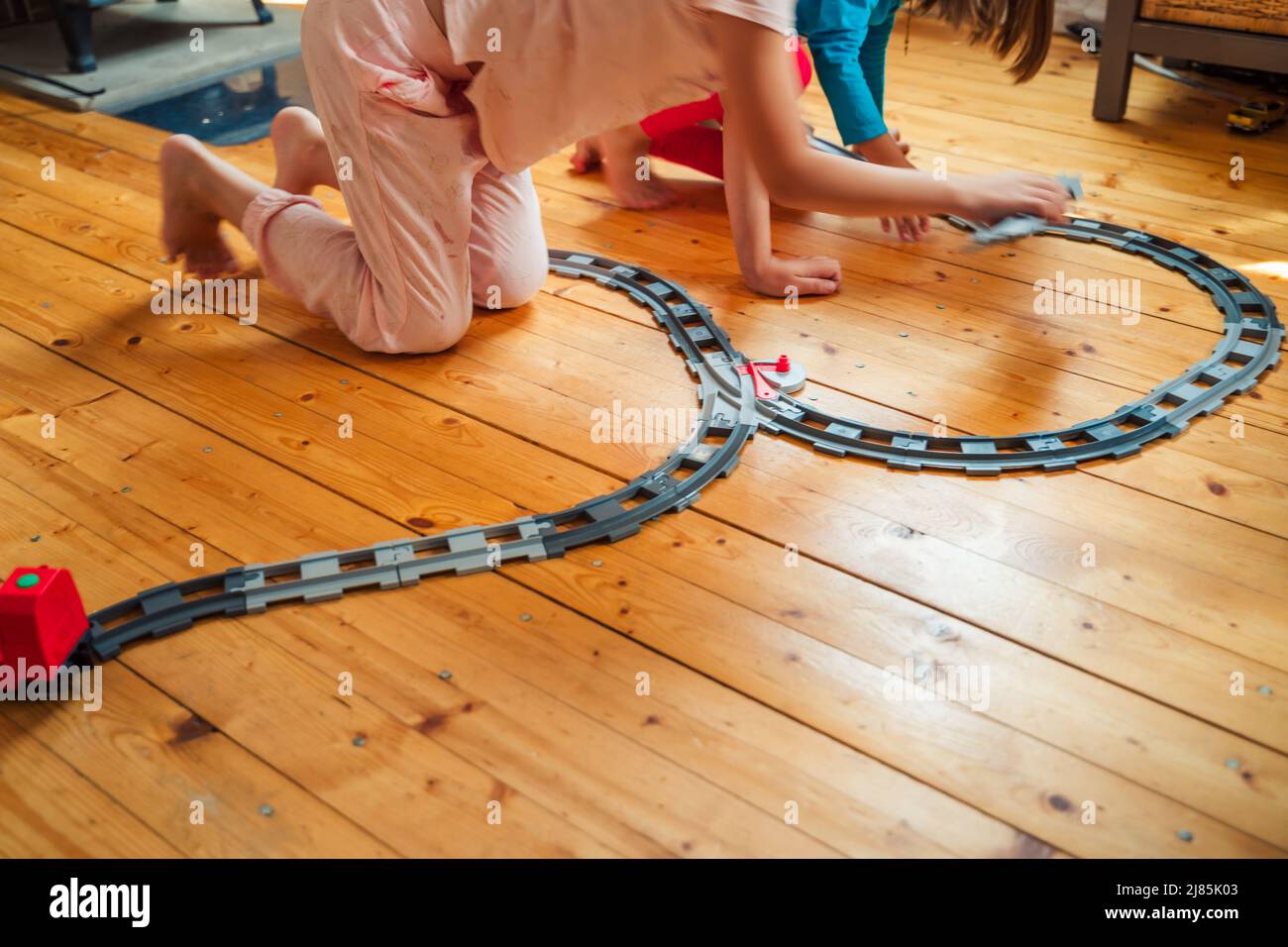 Girls, sisters play kids constructor, build toy railway, railroad by ...